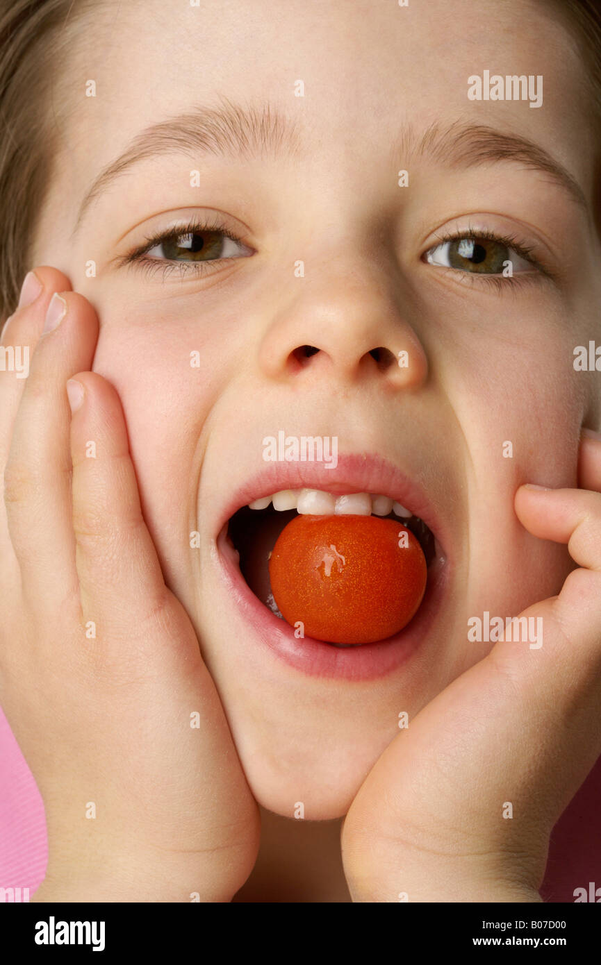Boy eating a tomato Stock Photo - Alamy