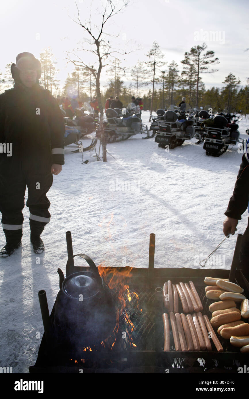 Group of tourist having barbecue picnic on a snowmobile safari tour in ...