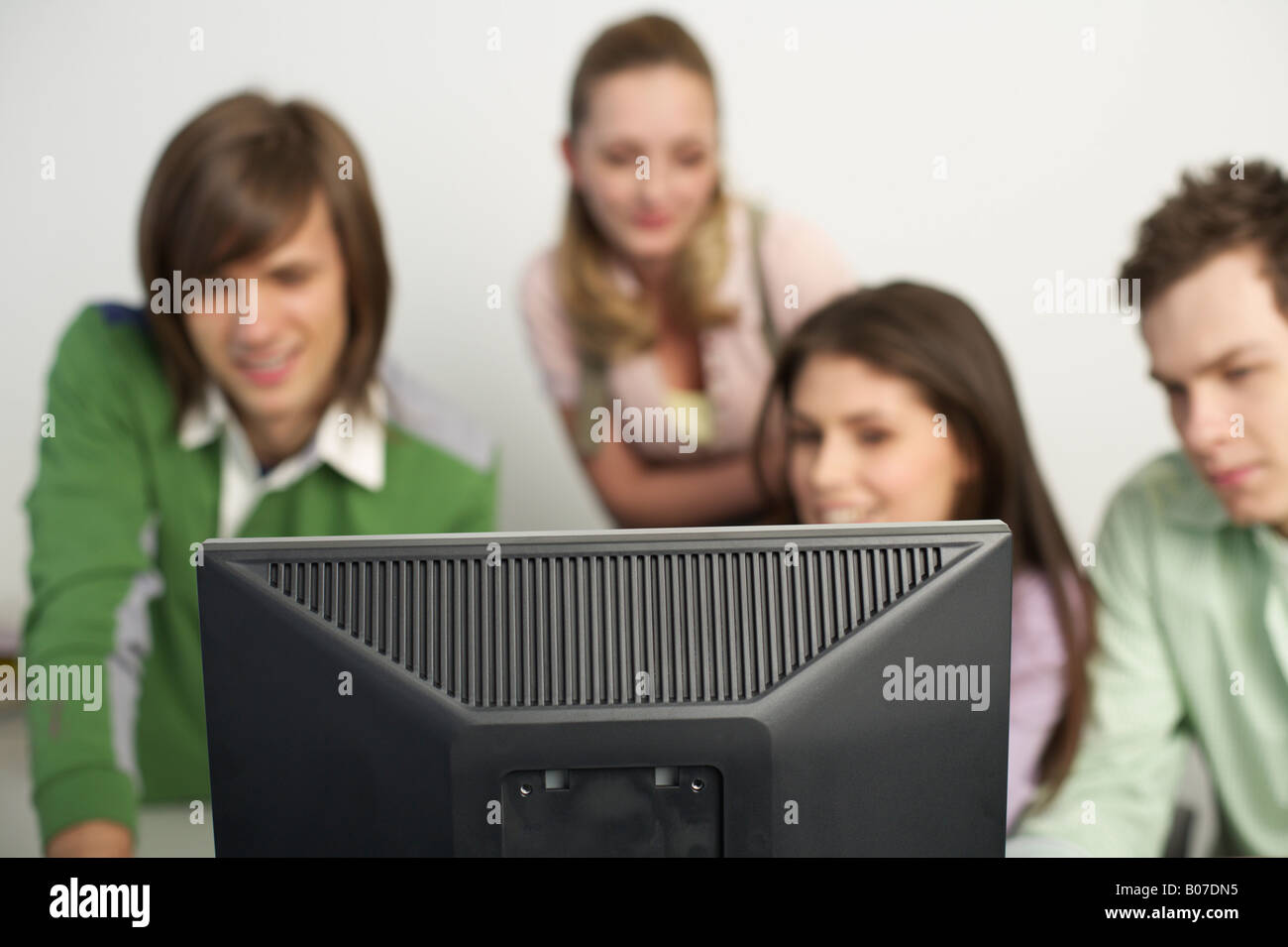 Young People looking at a monitor Stock Photo - Alamy
