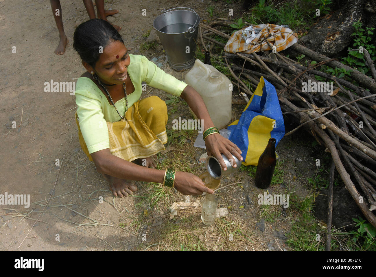 Woman filtering and selling alcohol. Katkari tribe Stock Photo - Alamy