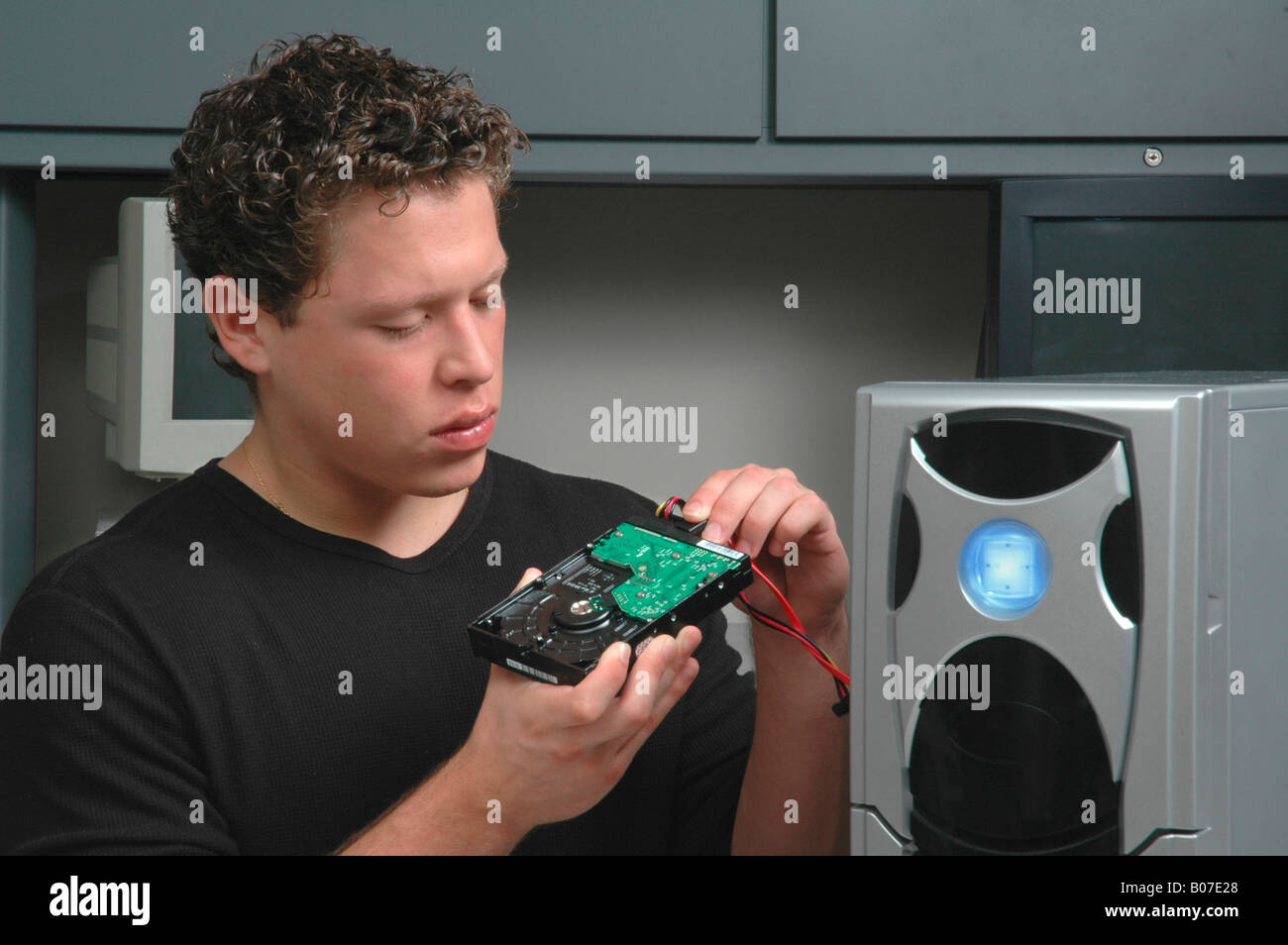Technician examining and servicing a computer server hard drive ...