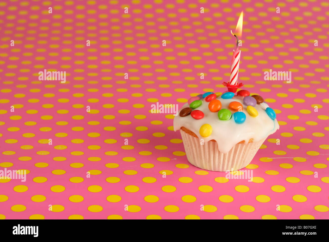 Birthday muffin with icing, sprinkles and candle Stock Photo - Alamy