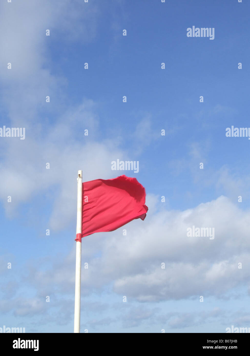 red warning flag in wind by beach Stock Photo - Alamy