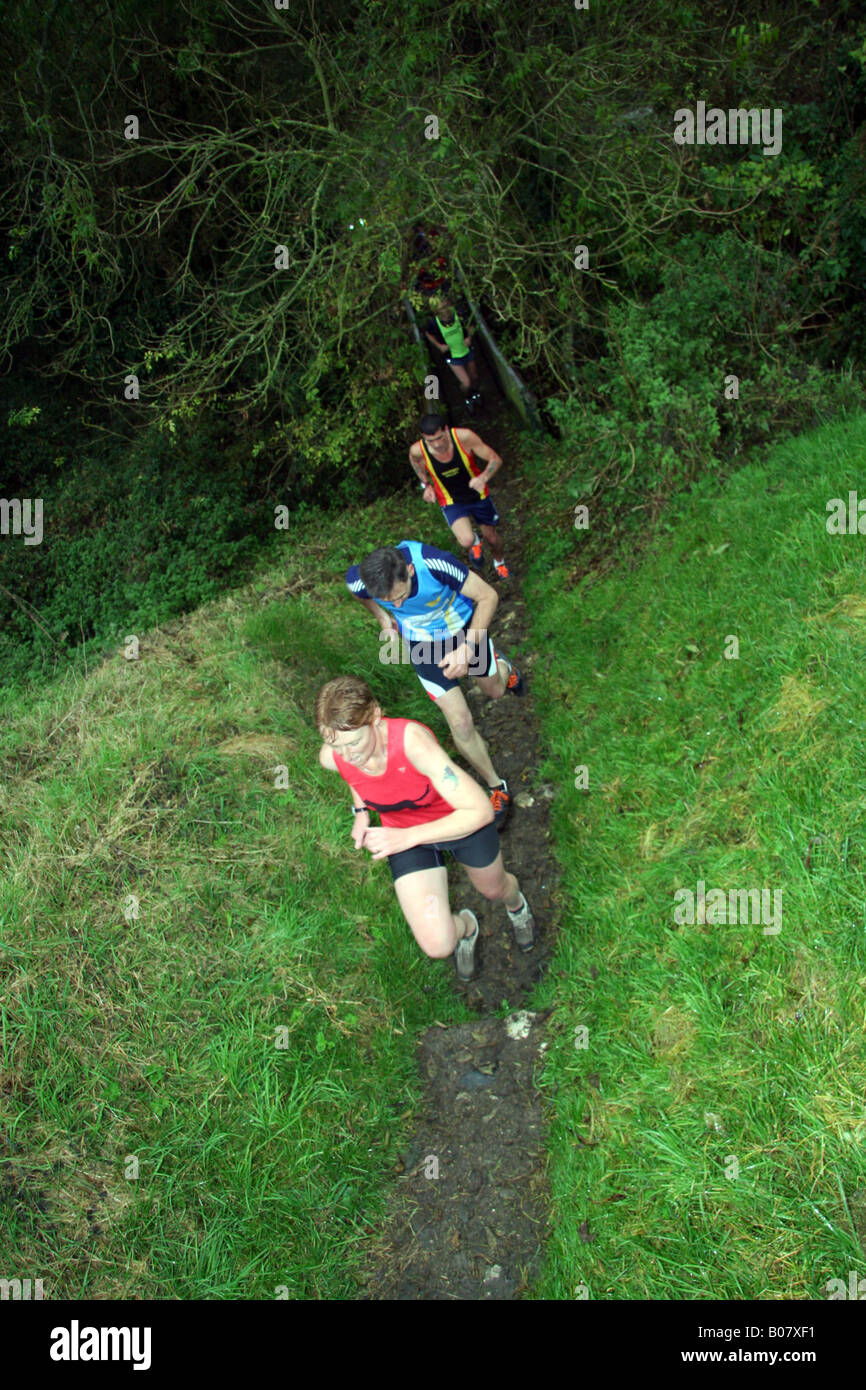 Four cross country runners on a steep, narrow path Stock Photo - Alamy