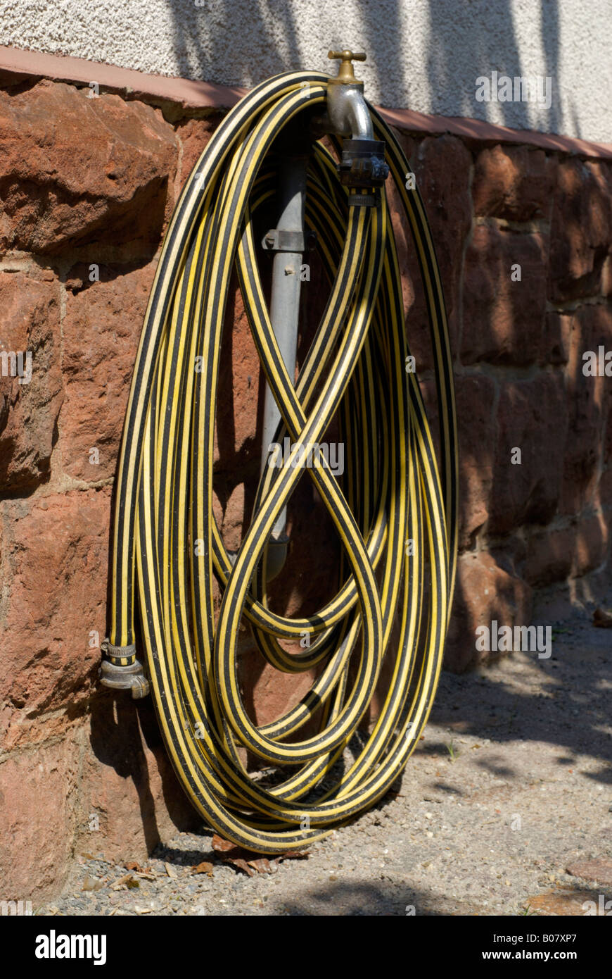 Rolled up garden hose Stock Photo - Alamy