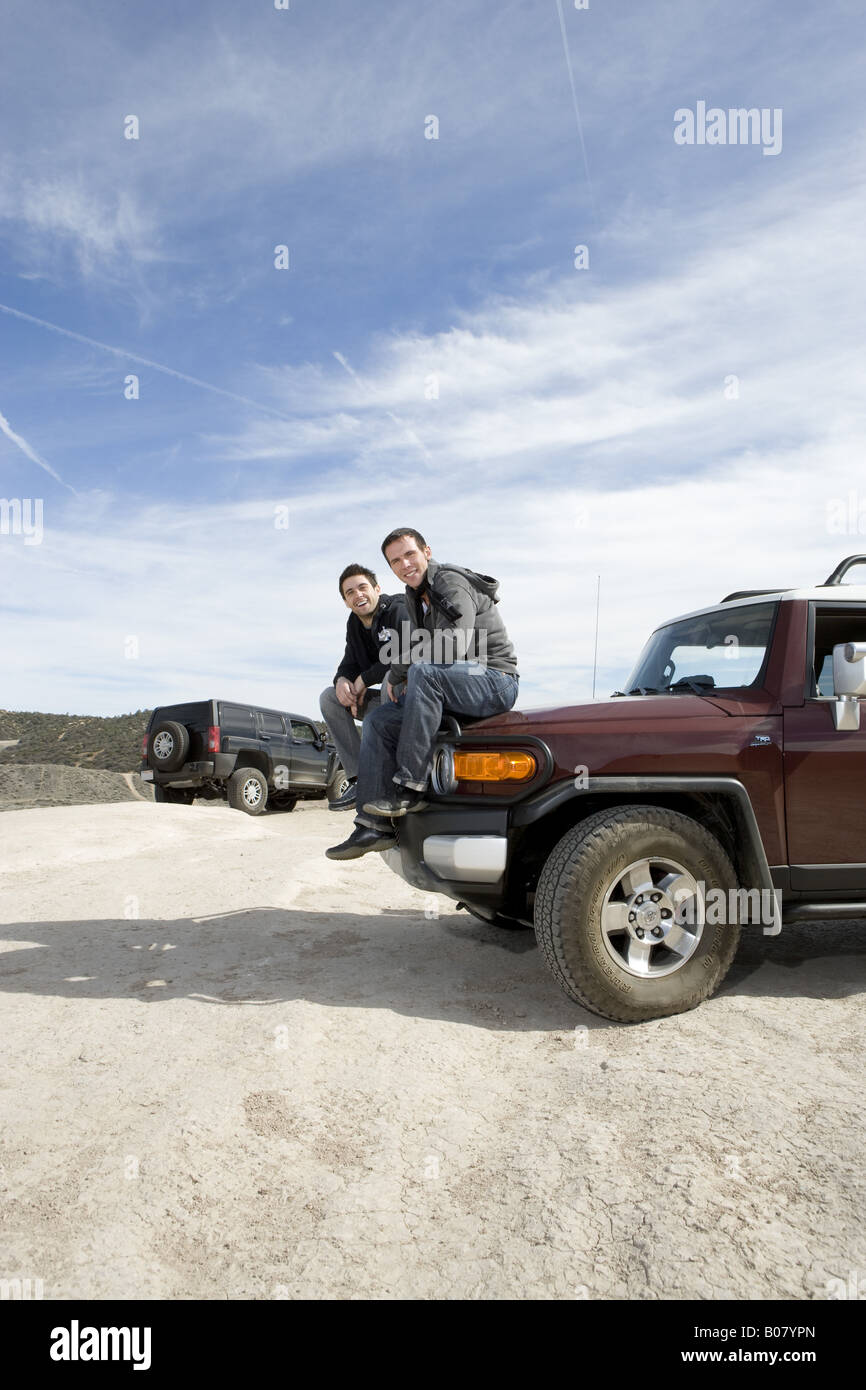 Two men sitting on their off-road vehicle in desert Stock Photo - Alamy