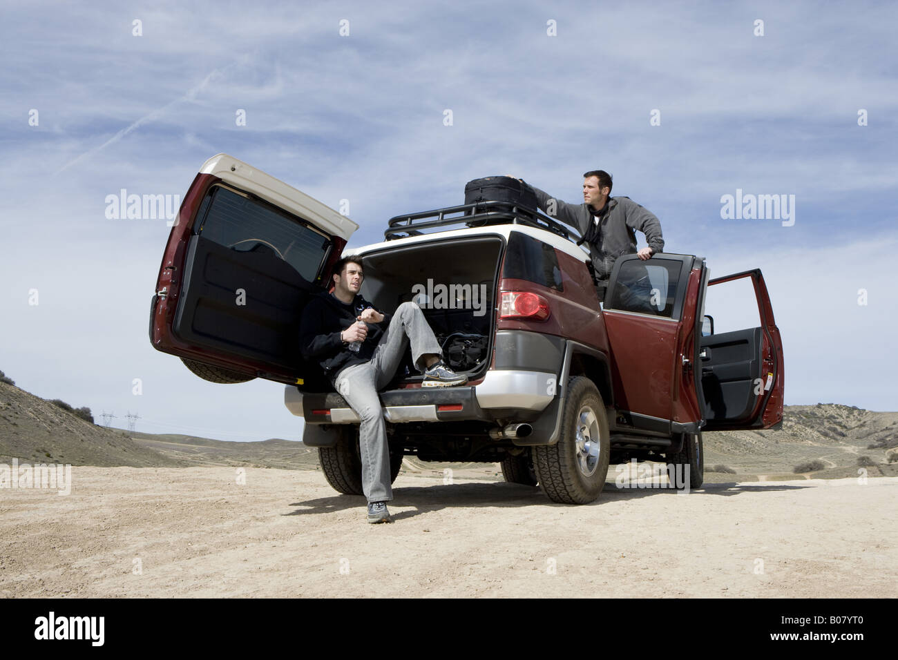 Two men relaxing in SUV off-road vehicle Stock Photo - Alamy