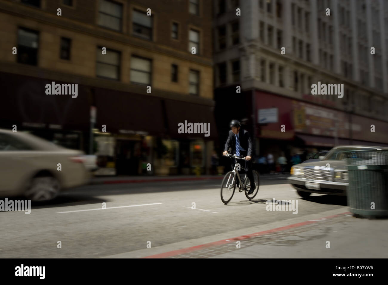 Businessman rides his bicycle down city street Stock Photo - Alamy