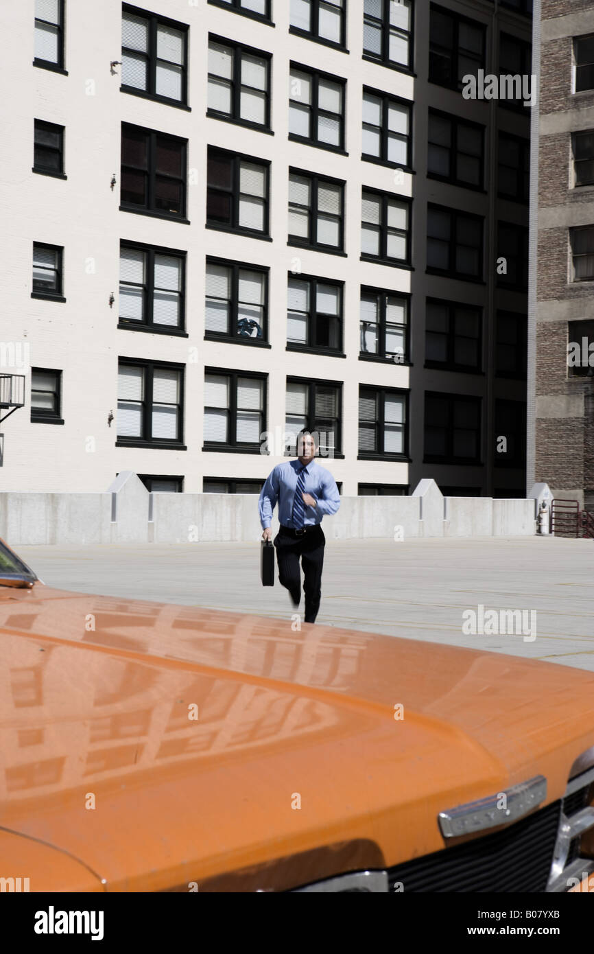 Businessman runs towards his car in rooftop car park Stock Photo - Alamy
