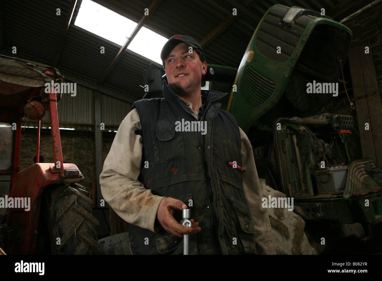 a portarit of a young farmer in north devon stood next to his farming ...