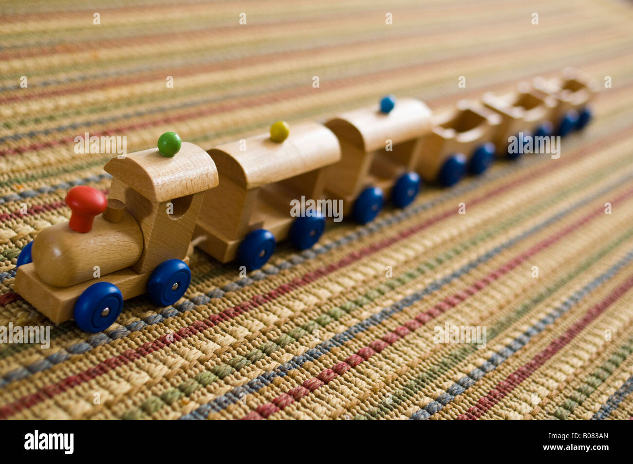 Wooden toy train on carpet Stock Photo - Alamy