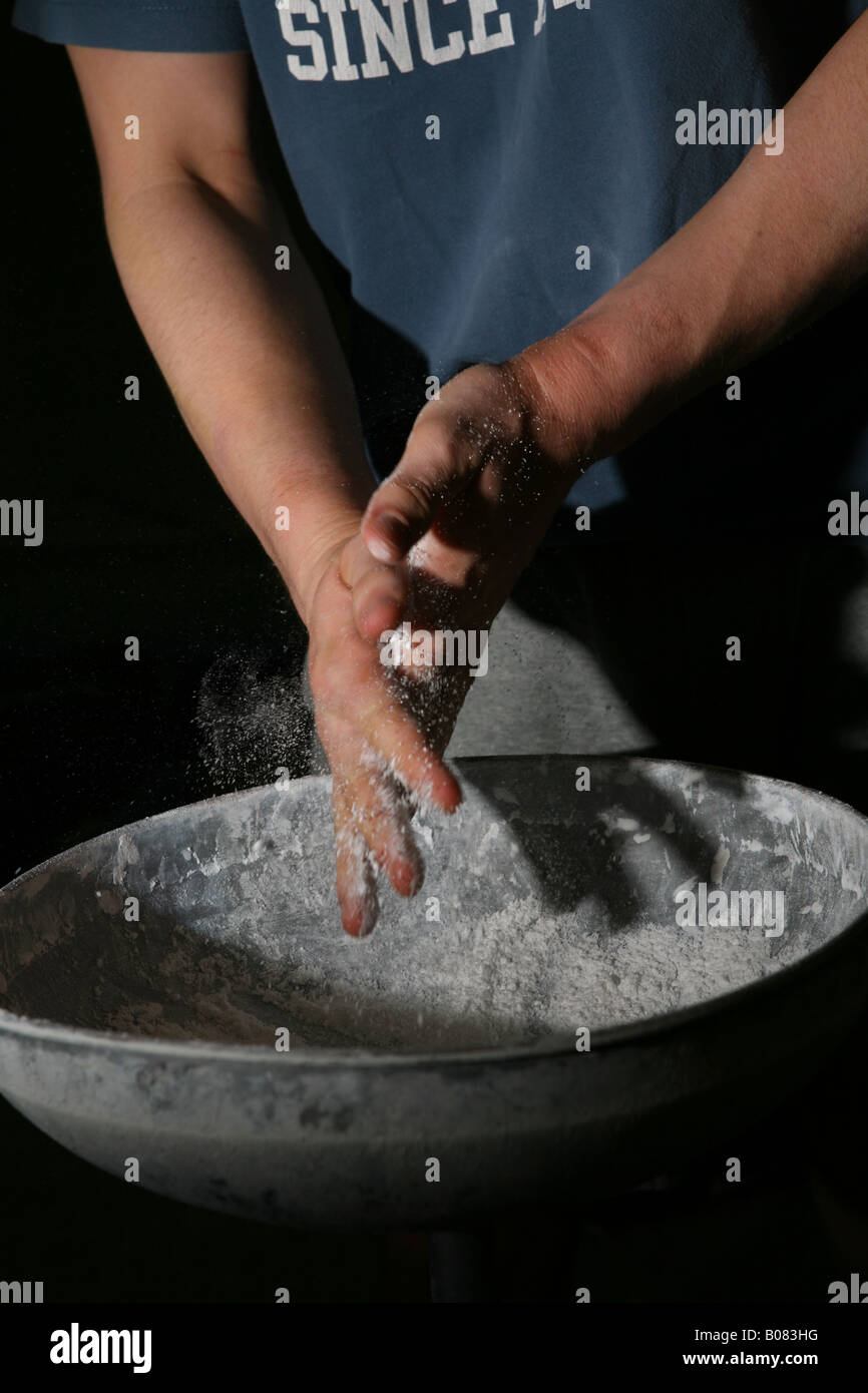 a gymnast putting chalk onto his hands before he starts his training ...
