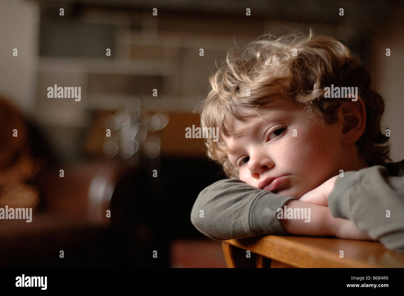 A young boy sitting alone Stock Photo - Alamy