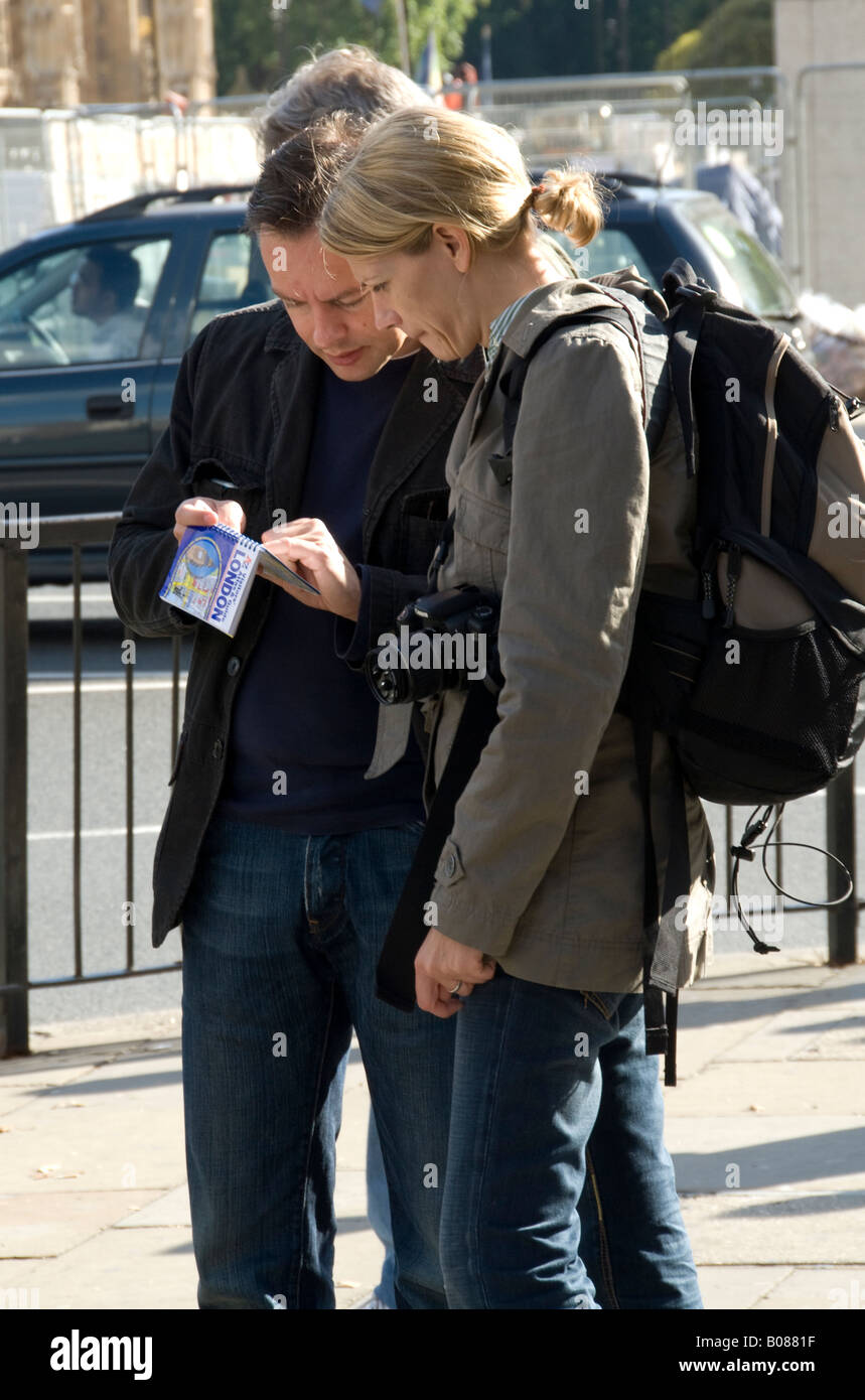 Two Western tourists looking at a guidebook in London, England, UK ...