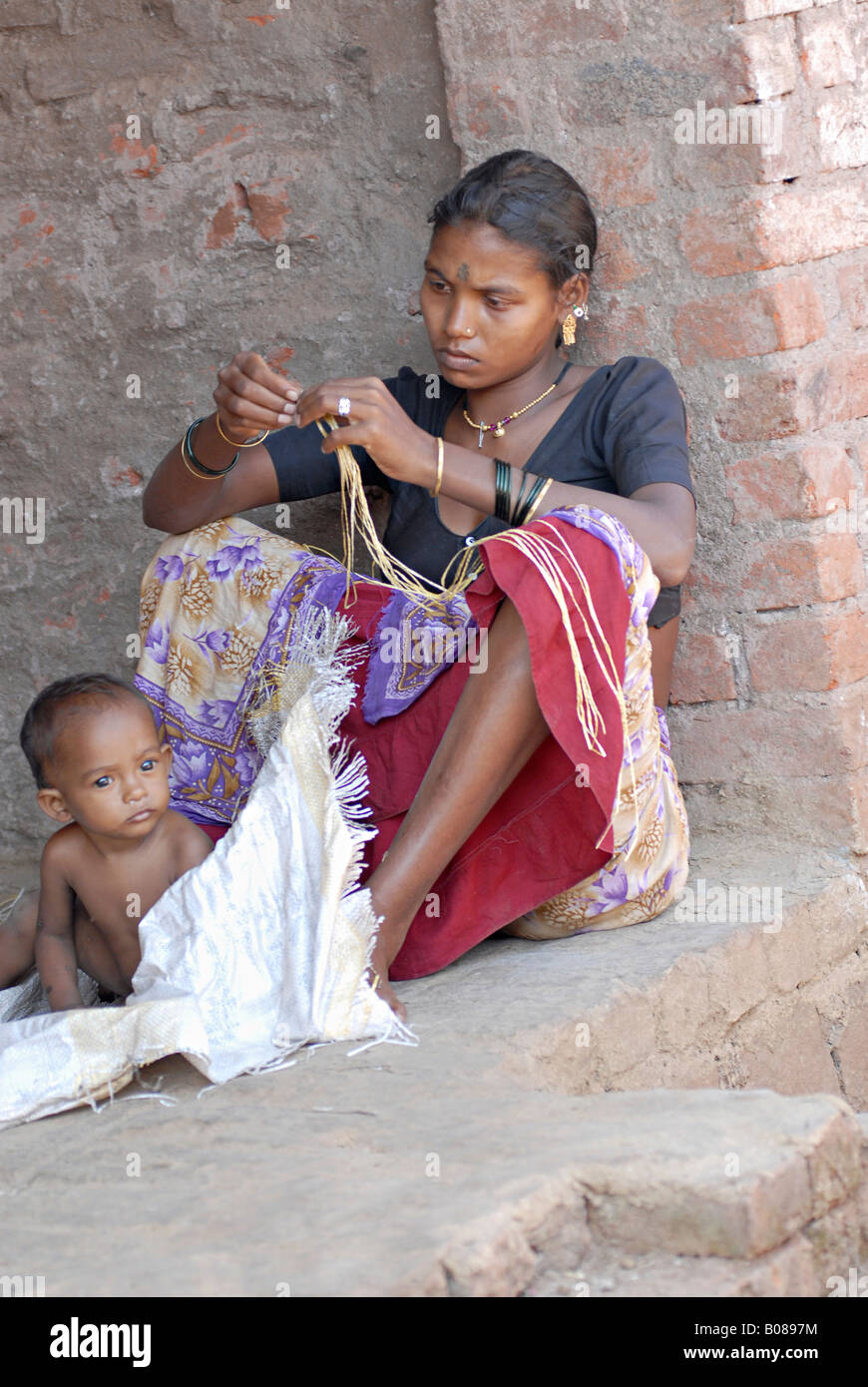 Woman weaving with her child besides her. Thakkar tribe Stock Photo - Alamy