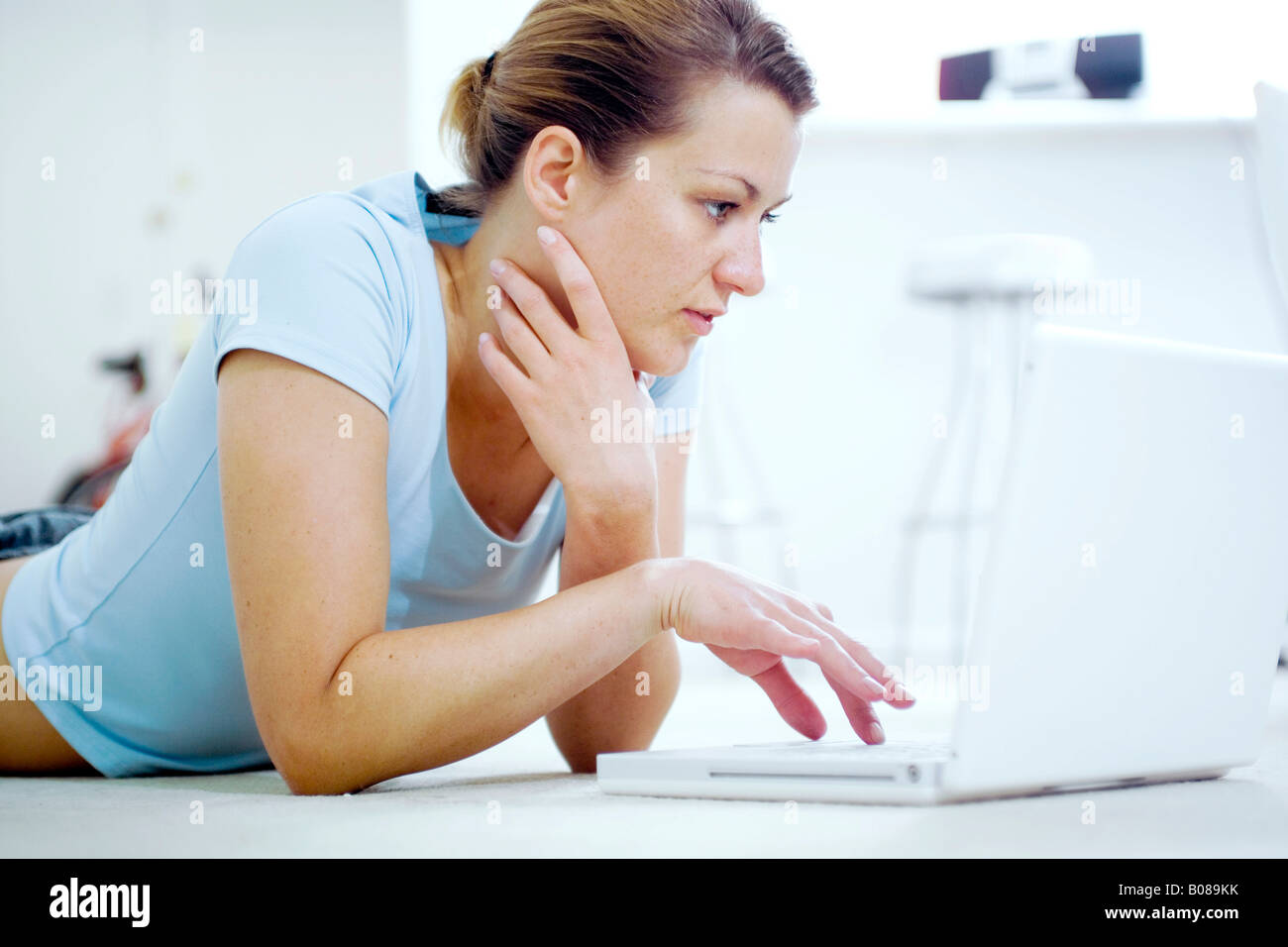 Woman on floor working on computer Stock Photo - Alamy