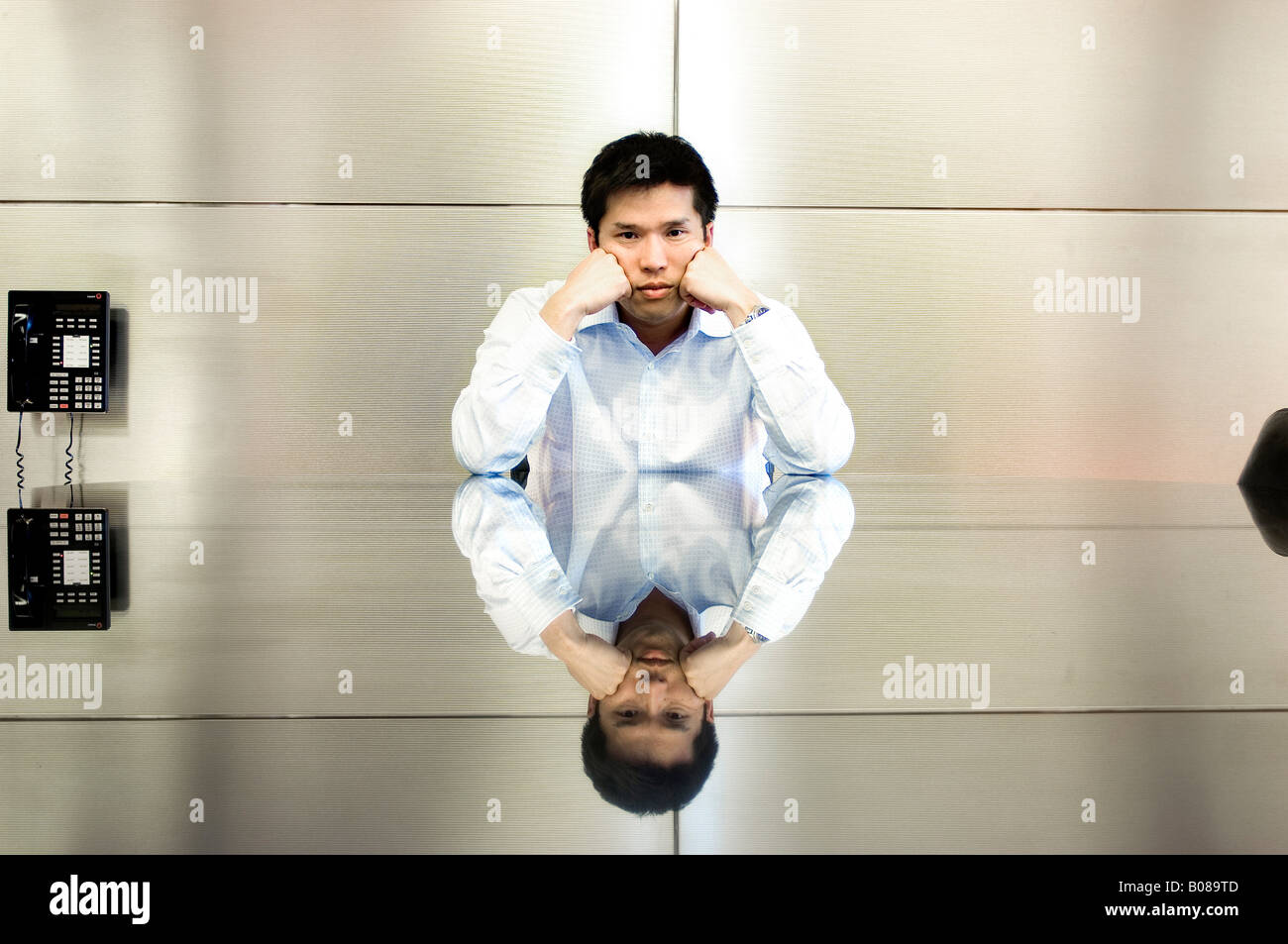 Businessman leaning on table Stock Photo - Alamy