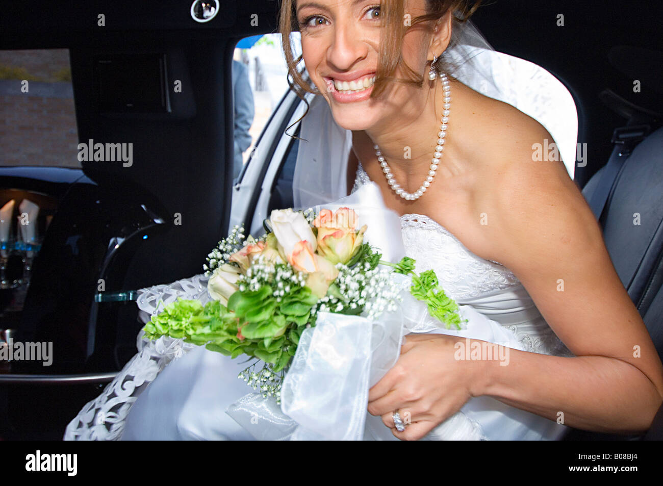 Bride getting out of limo Stock Photo - Alamy