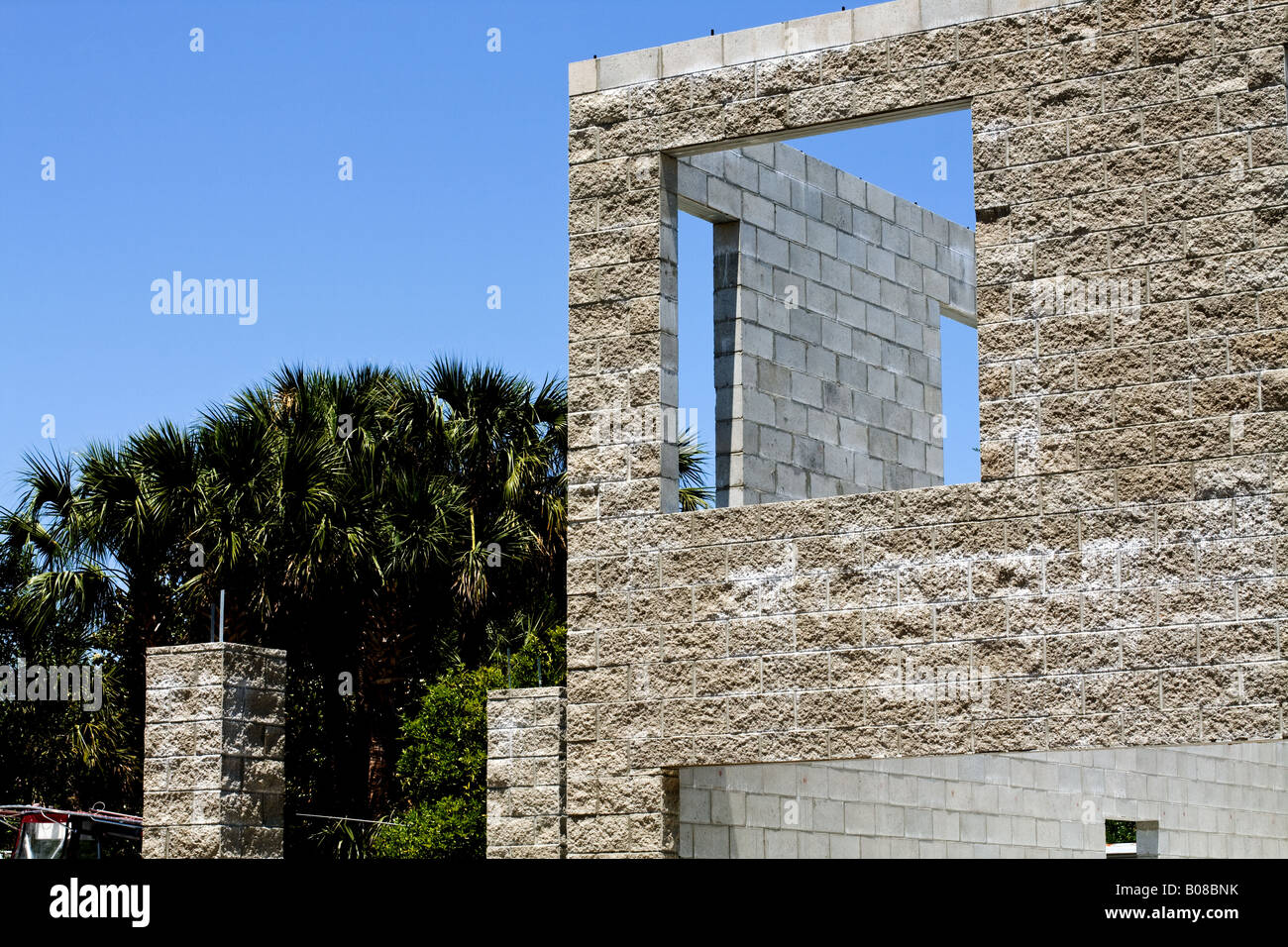 Partially built stone building with posts and trees in the background ...