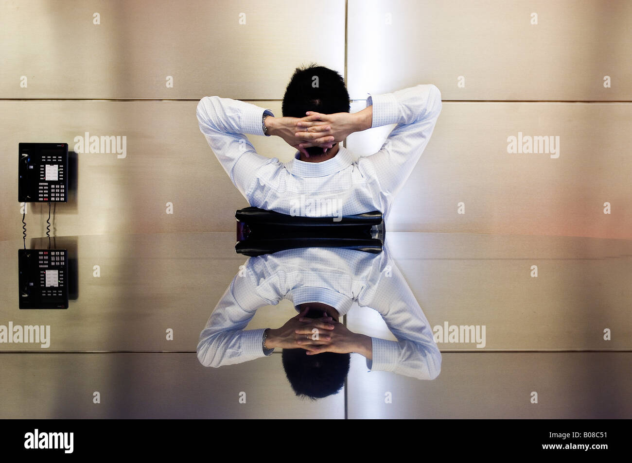 Businessman leaning back in chair Stock Photo - Alamy