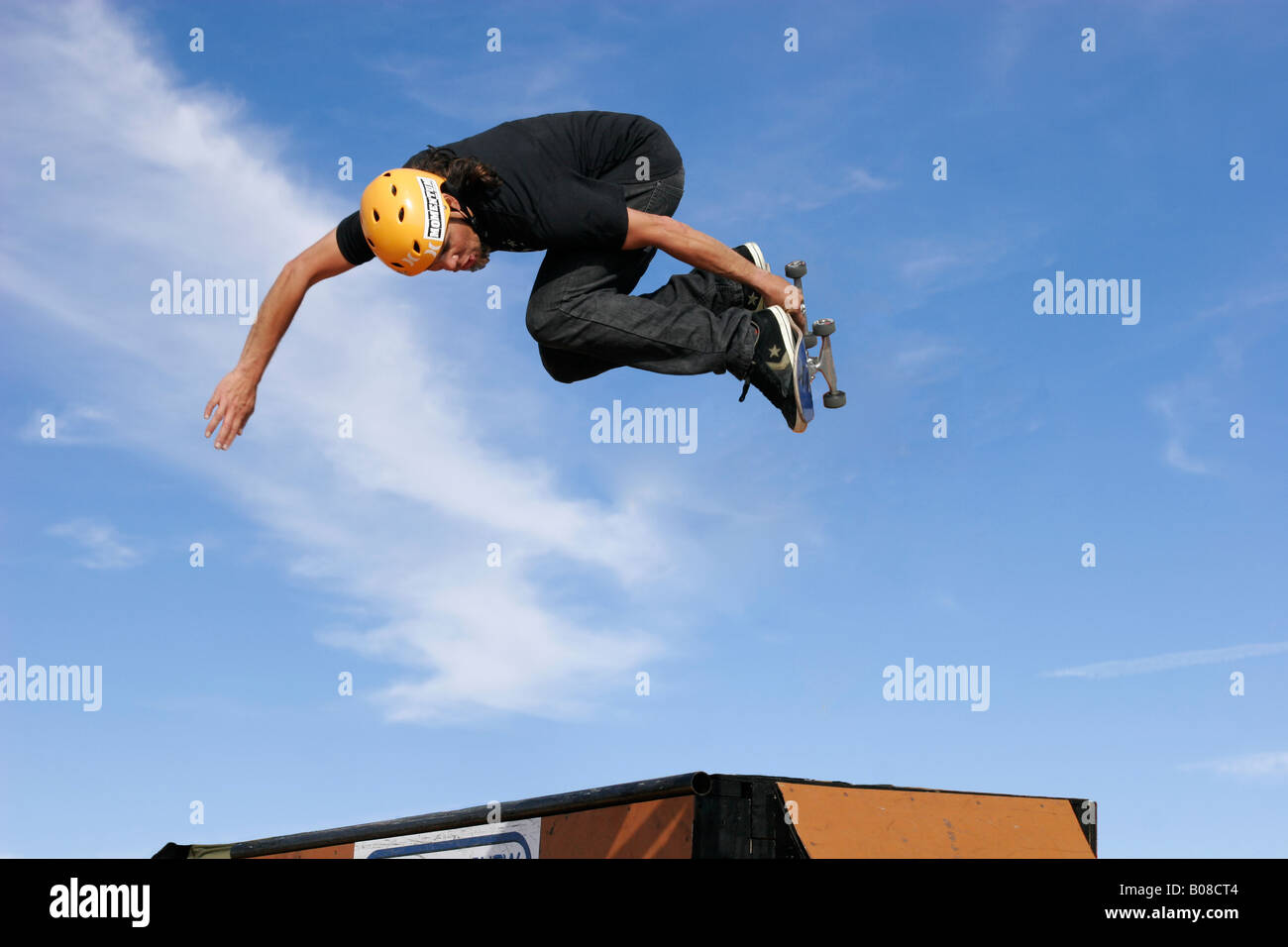 Skateboarder performing a stunt Stock Photo - Alamy