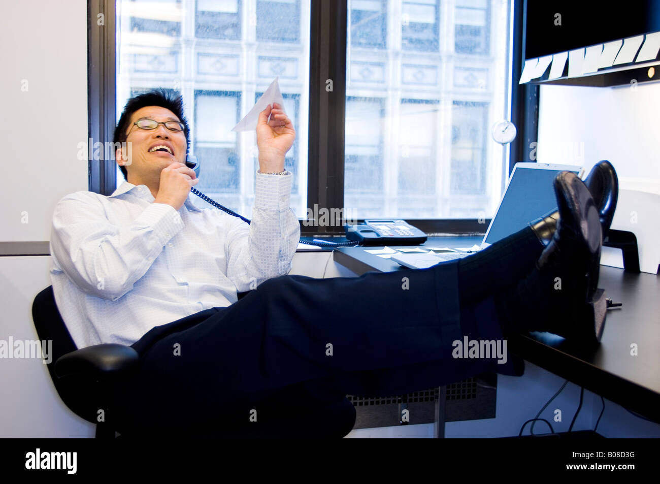 Businessman at desk talking on phone feet on desk Stock Photo - Alamy
