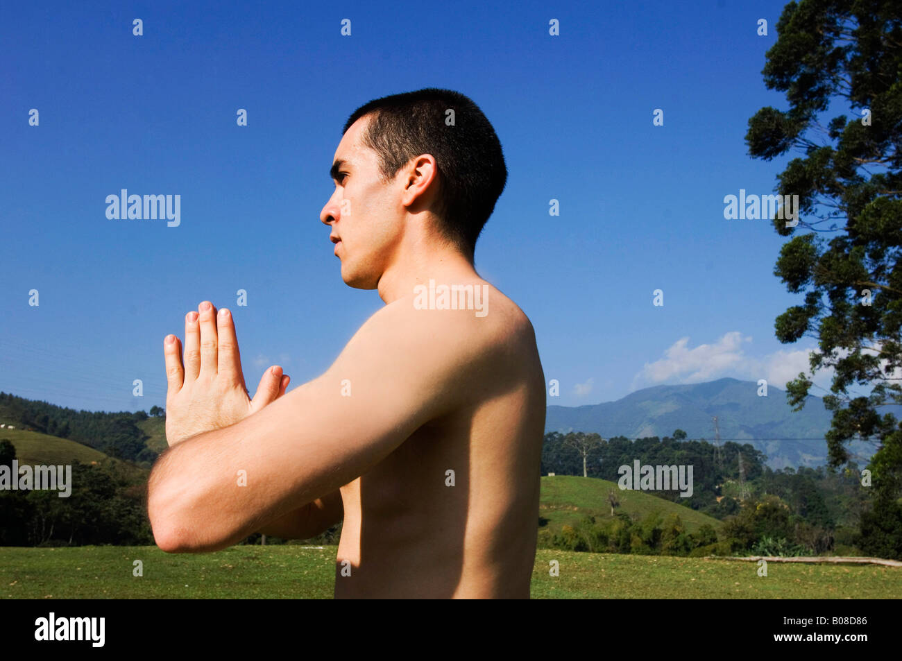 Young man doing yoga outdoors Stock Photo - Alamy