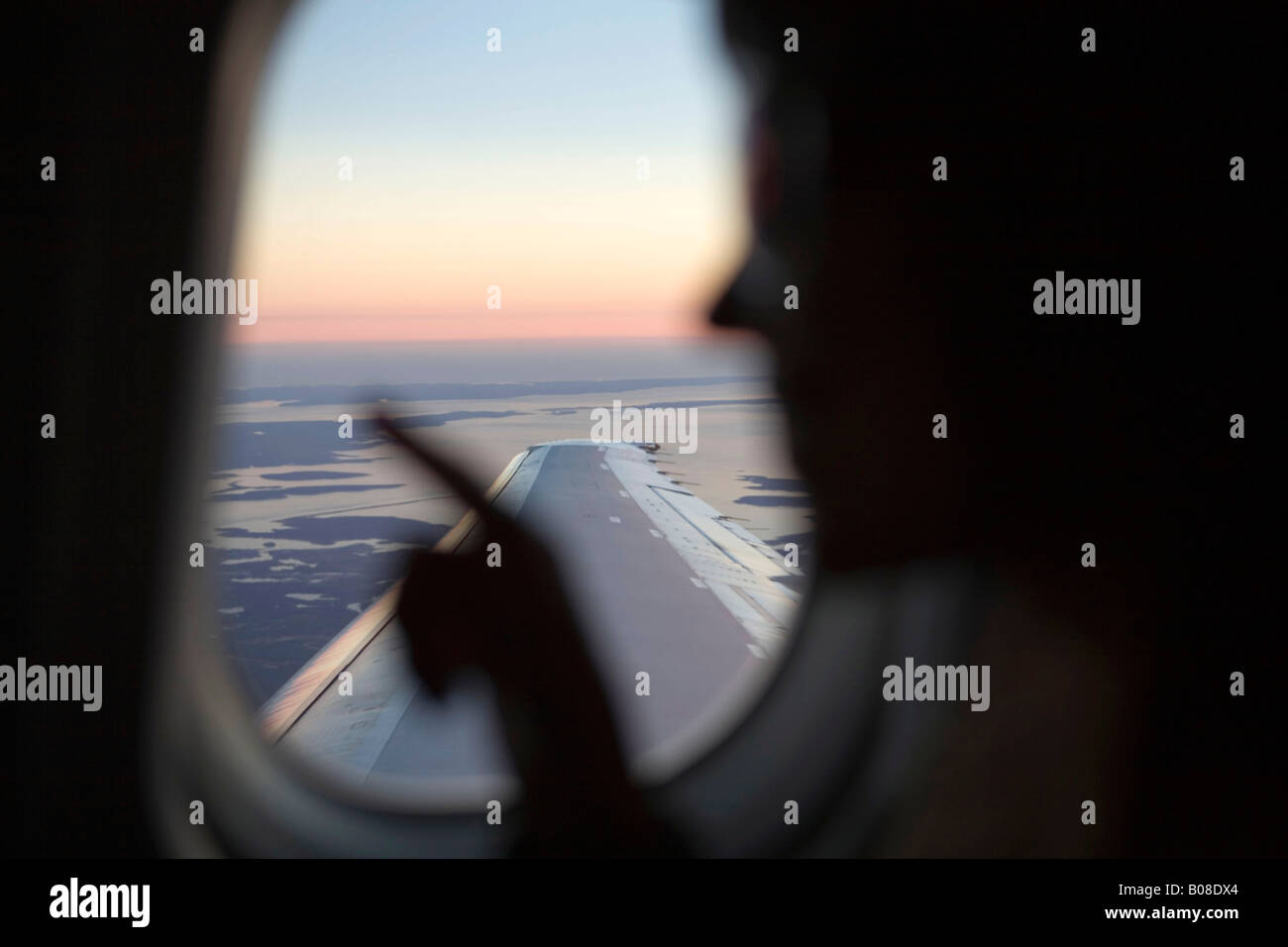 Person looking through airplane window Stock Photo - Alamy