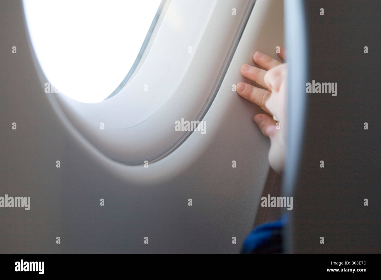 Child looking out airplane window Stock Photo - Alamy