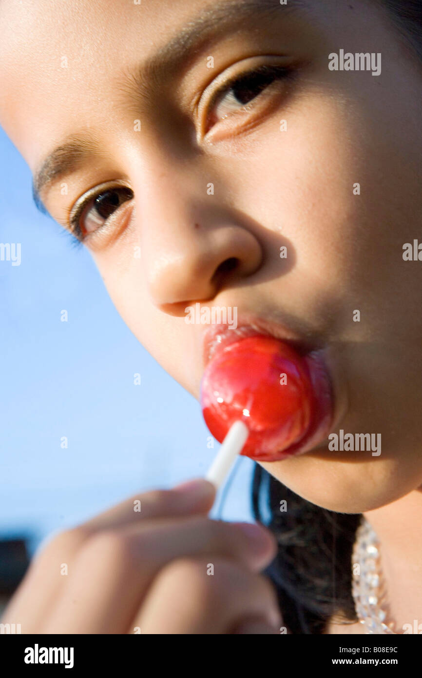 Young girl eating lollipop Stock Photo - Alamy