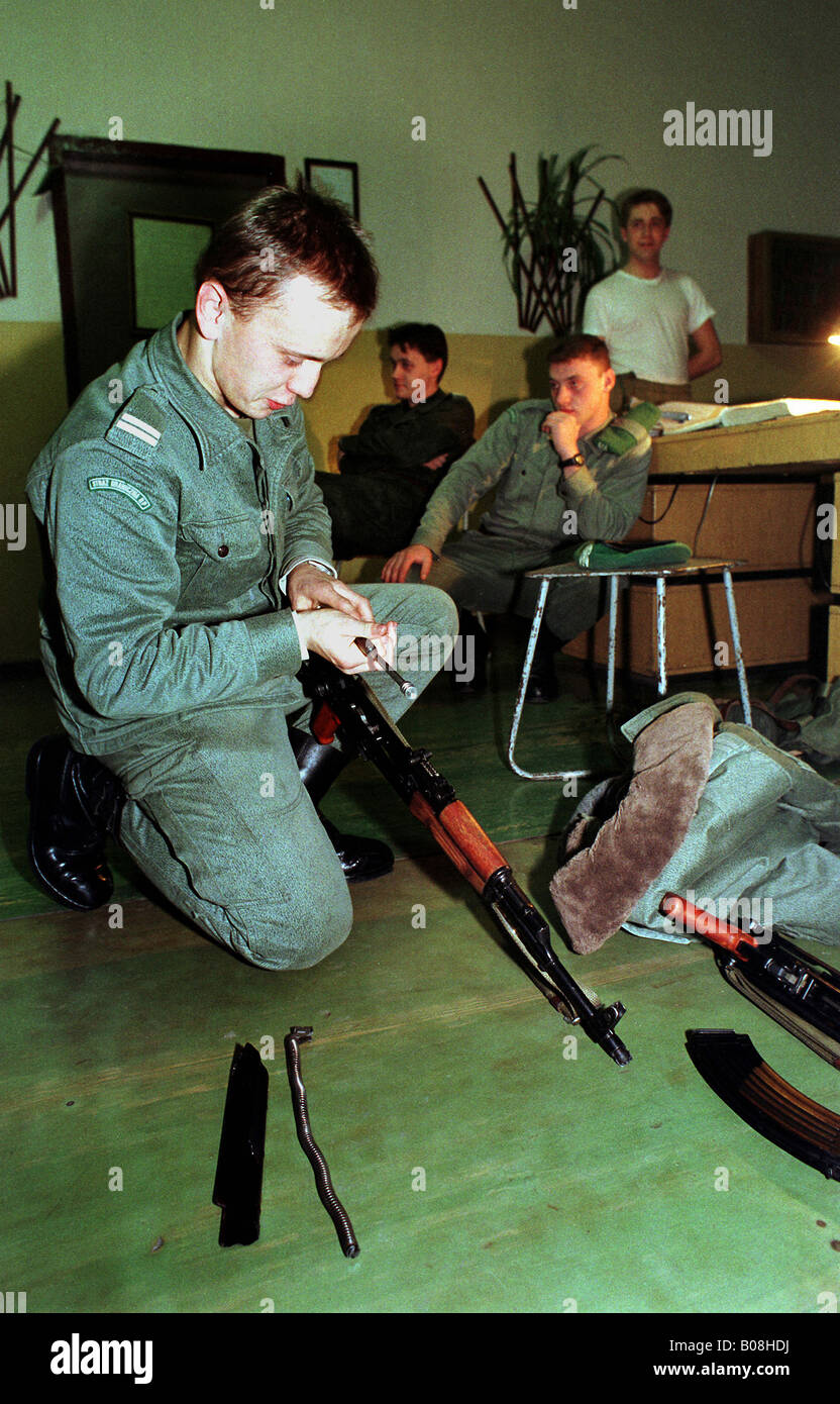 Polish border guard officer preparing a rifle for a night patrol ...