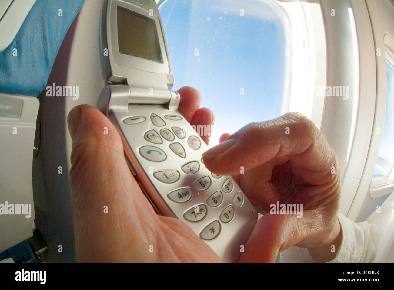 Person in airplane using cell phone Stock Photo - Alamy