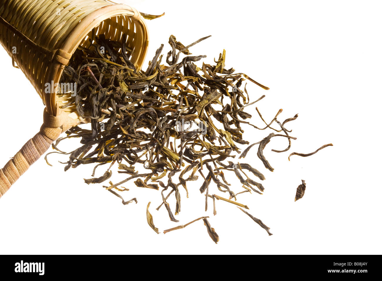An overflowing heap of raw tea spilling out of a woven scooper Stock ...