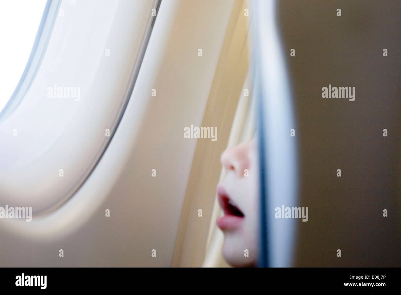 Child looking out airplane window Stock Photo - Alamy