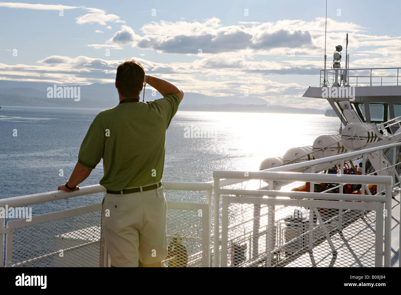 Man on ship sightseeing Stock Photo - Alamy