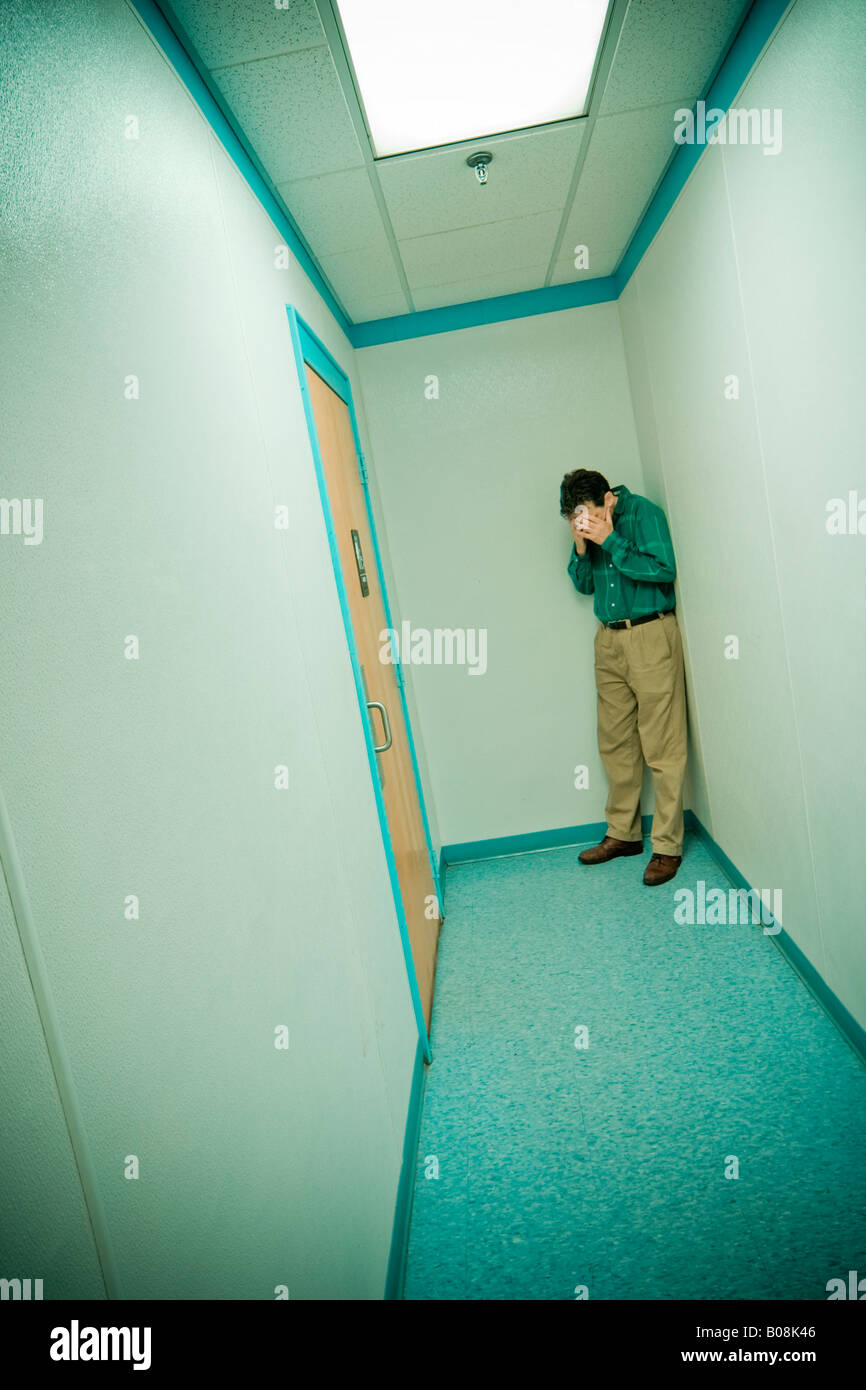 Man leaning against the wall at the end of a long hallway MODEL AND ...