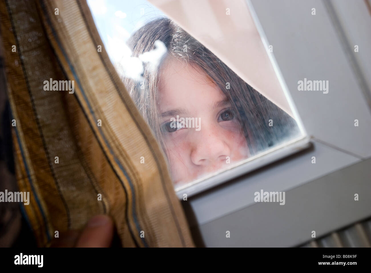 Preteen girl looking through a window into a motel room MODEL RELEASED ...