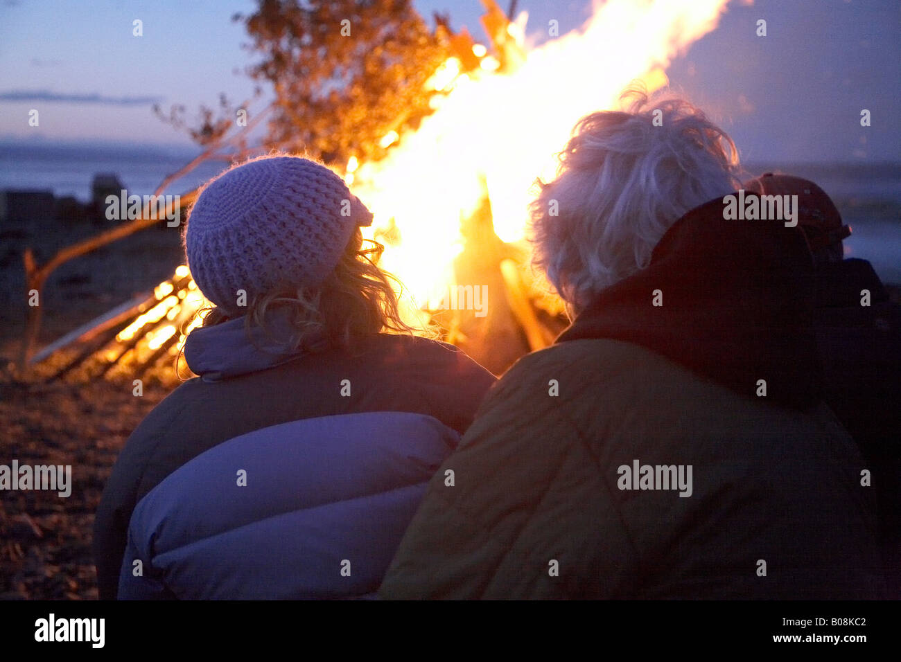 two women talking sitting outside next to bonfire Stock Photo - Alamy