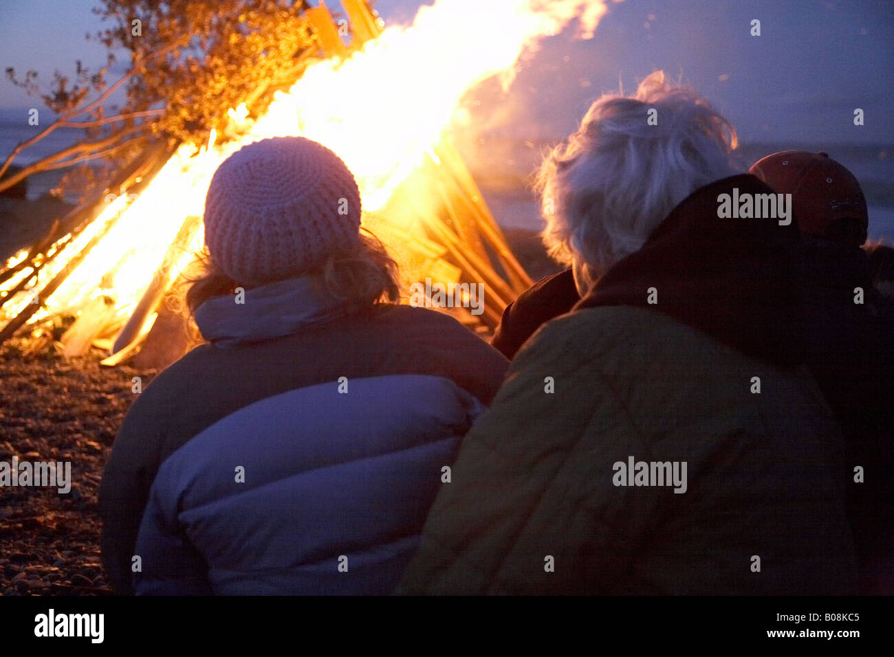 two women talking sitting outside next to bonfire Stock Photo - Alamy