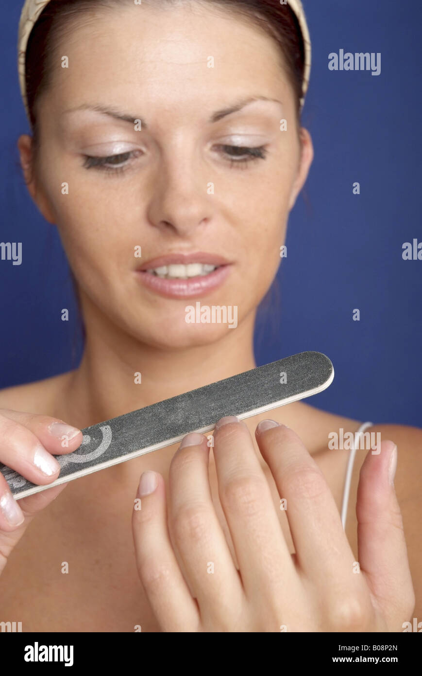 young cute woman using a nail fail Stock Photo - Alamy