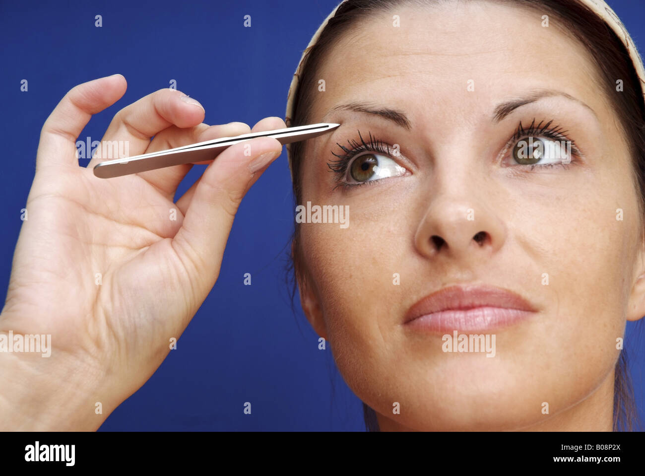 young cute woman plucking her brows Stock Photo - Alamy