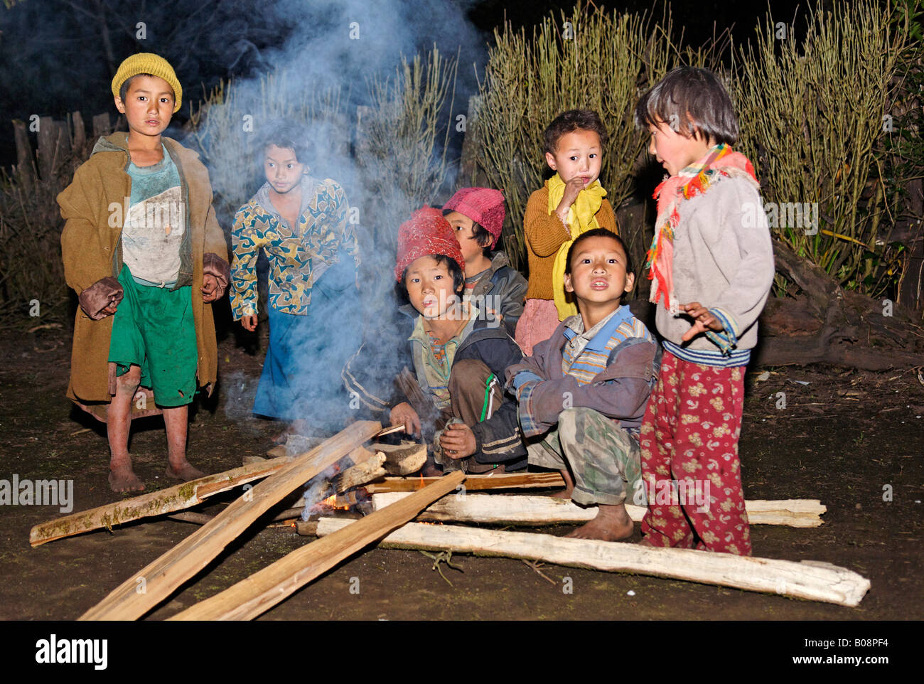 Poor Rawang children warming themselves in front of a fire, Kachin ...