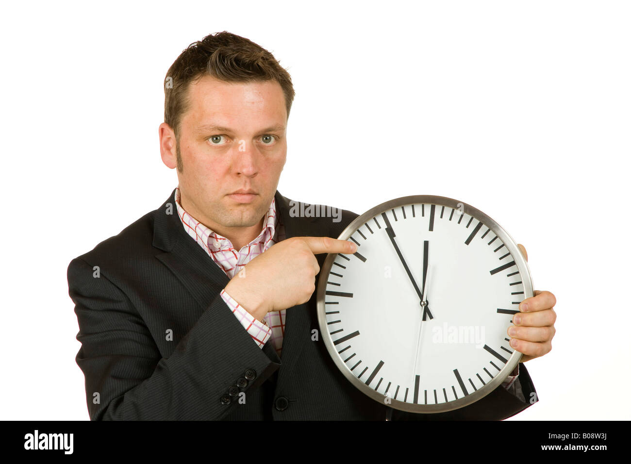 40-year-old businessman pointing at a clock, time is 5 to 12 Stock ...