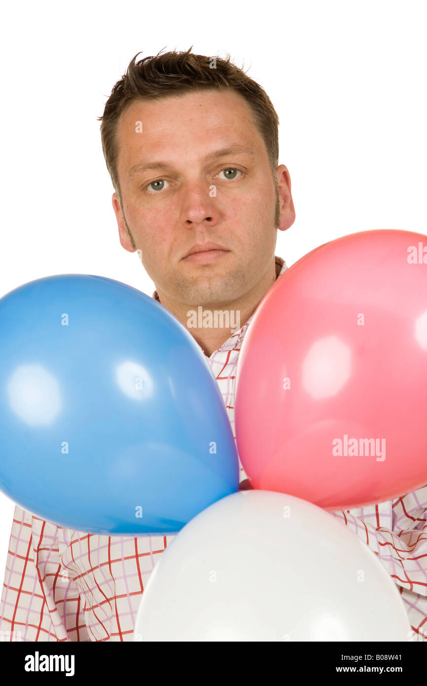 40-year-old man holding balloons, looking serious Stock Photo - Alamy