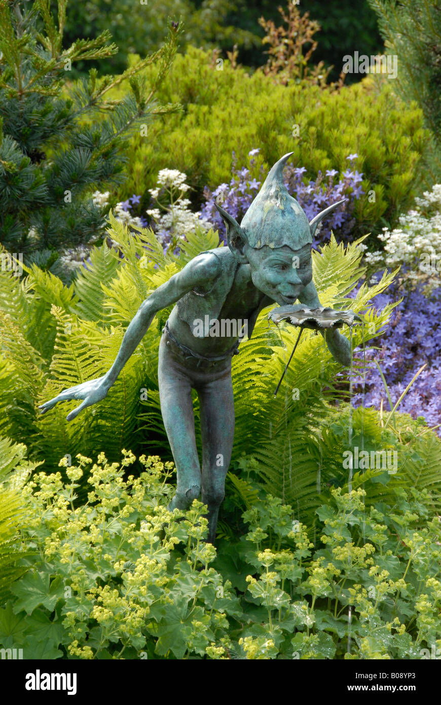 Cheeky nymph water feature amongst colorful shrubs and flowers Stock ...