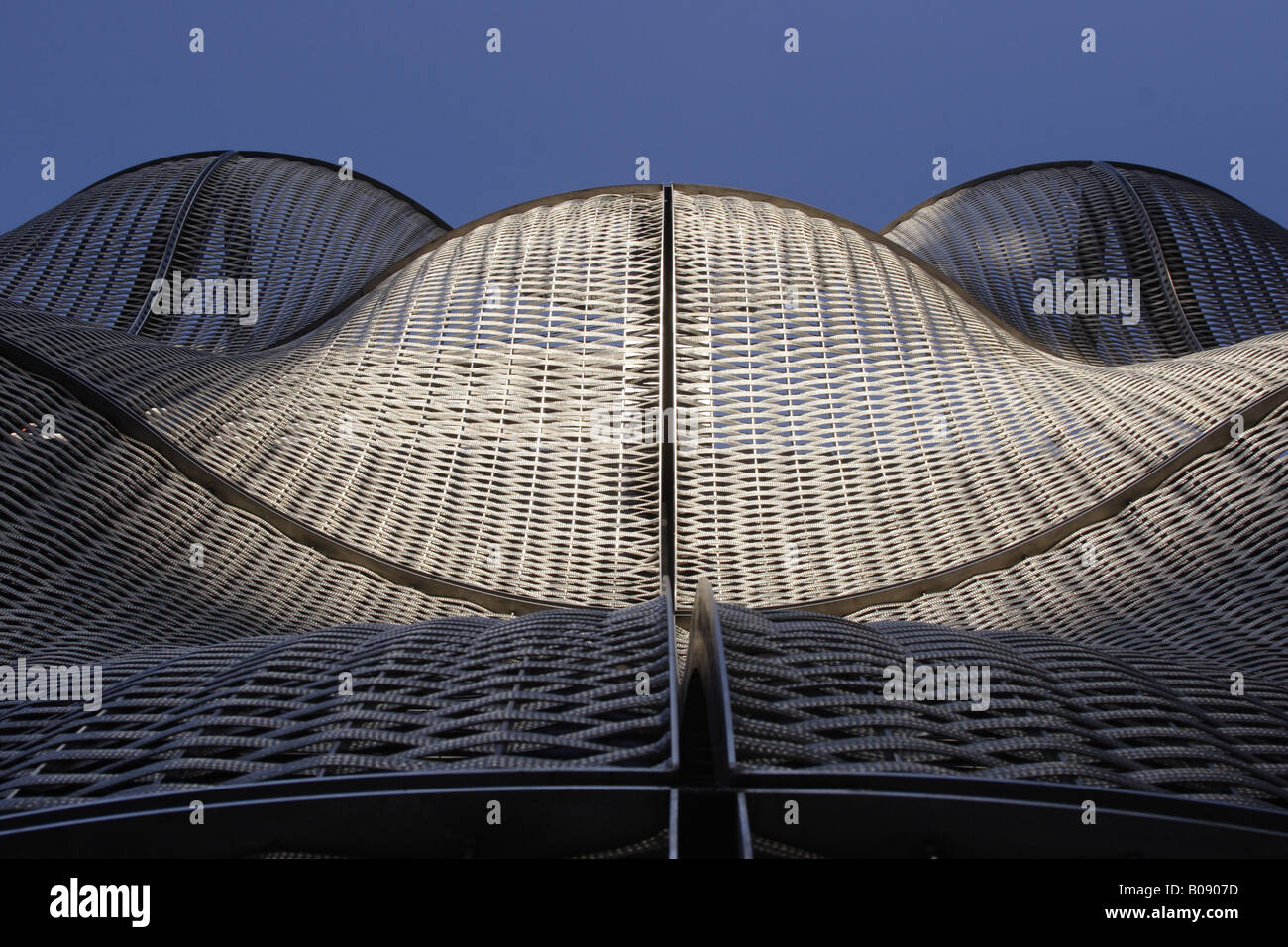 Waves of an architectural cladding of a steel weave at dusk Stock Photo ...