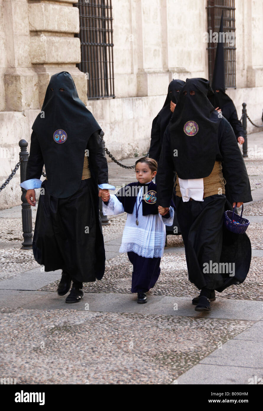 Penitents dressed in black penitential robes (nazareno) with child on ...