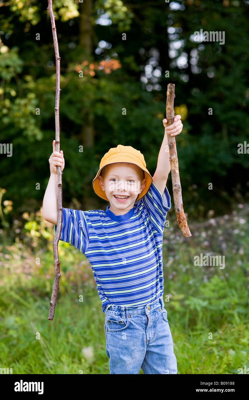 Four-year-old boy collecting sticks in a forest Stock Photo - Alamy