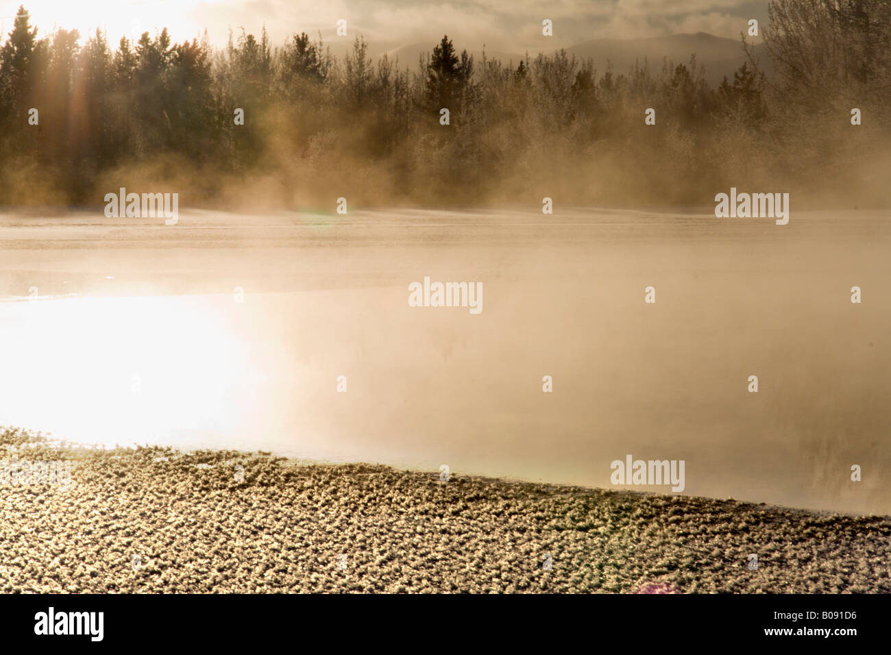Mist rising from a frozen lake in the sunlight, Takhini Hot Springs ...