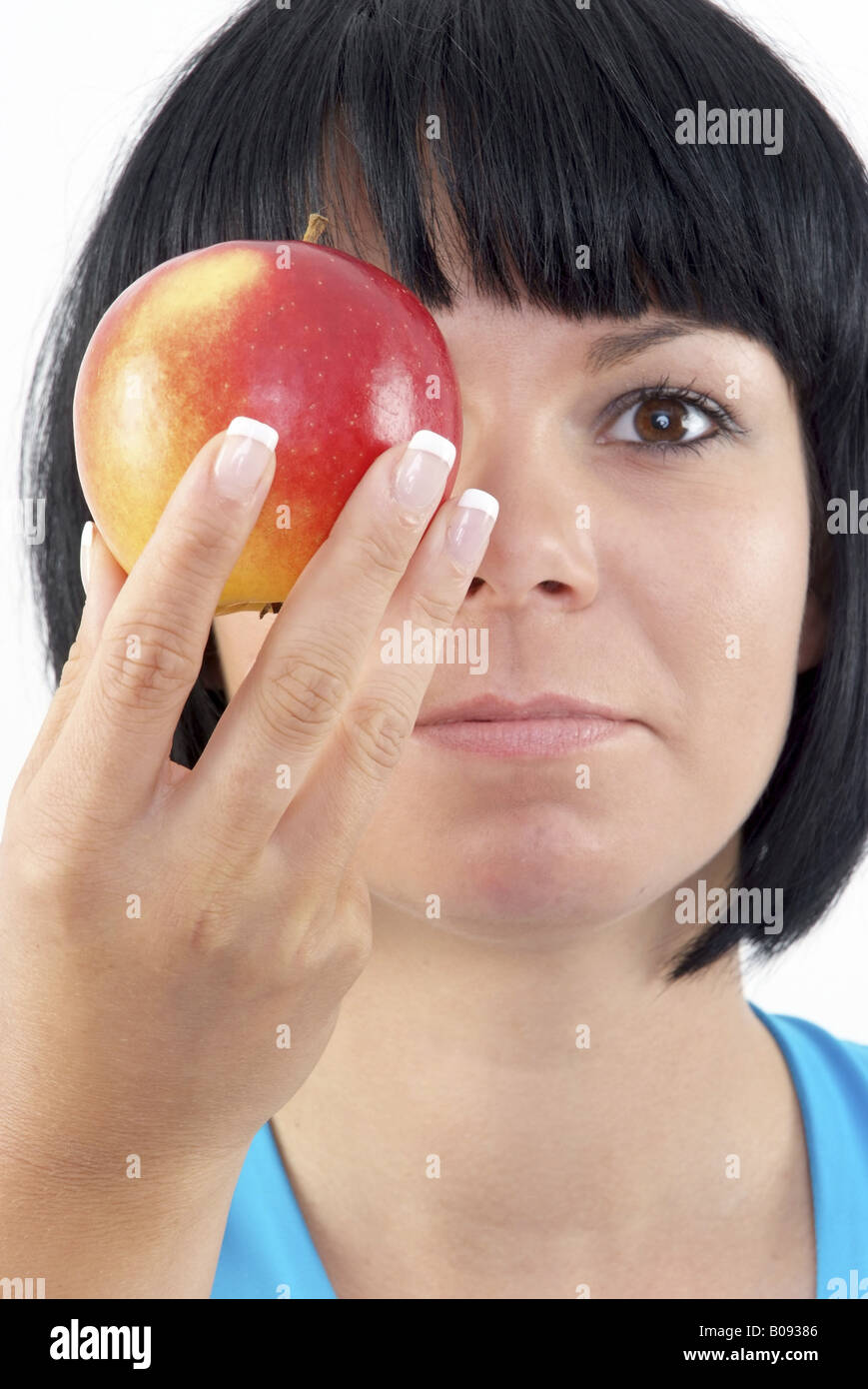 black-haired women holding an apple in front of her face Stock Photo ...